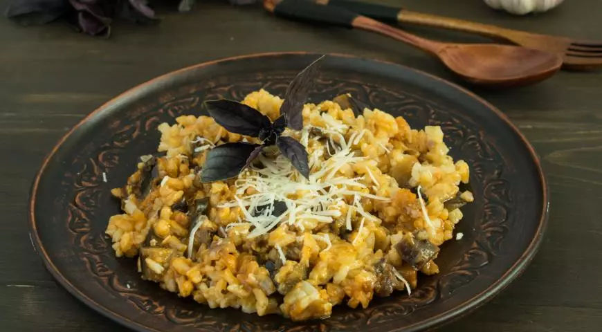 Espolvoree risotto con parmesano y decore la albahaca.