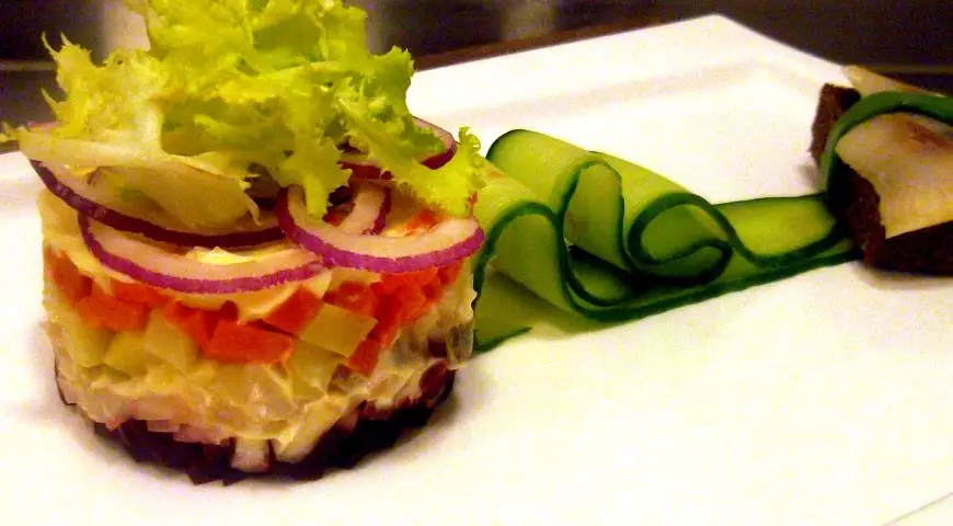 Disporre insalata con aringhe e barbabietole attraverso un anello culinario