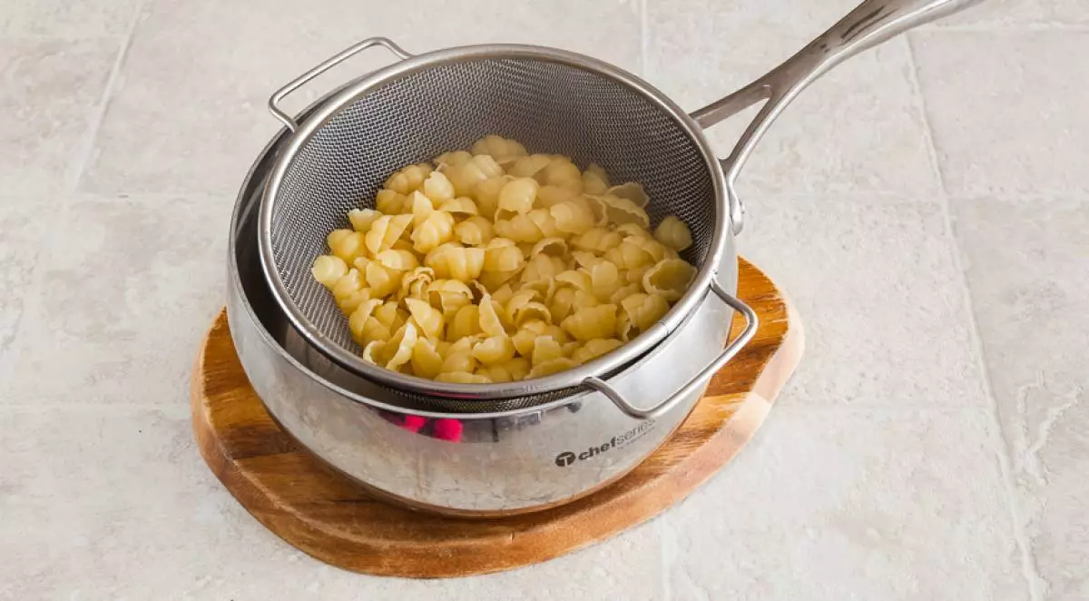 Bika iyo paste mumvura yakazaruka, kusendama pane colander, siya chikamu chemvura