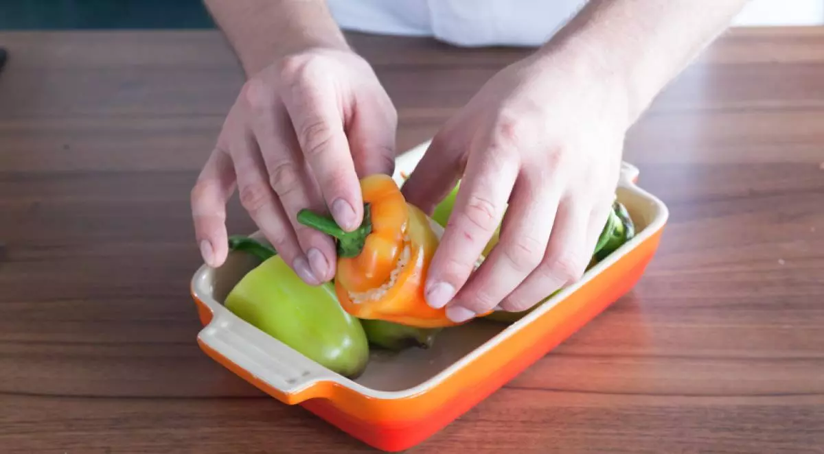 Peper gevuld met wortels en rijst. Zet in de vorm voor het bakken