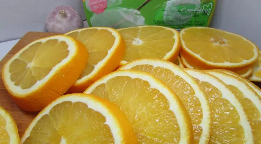 Нарэзаць апельсіны лустачкамі для запякання курыцы