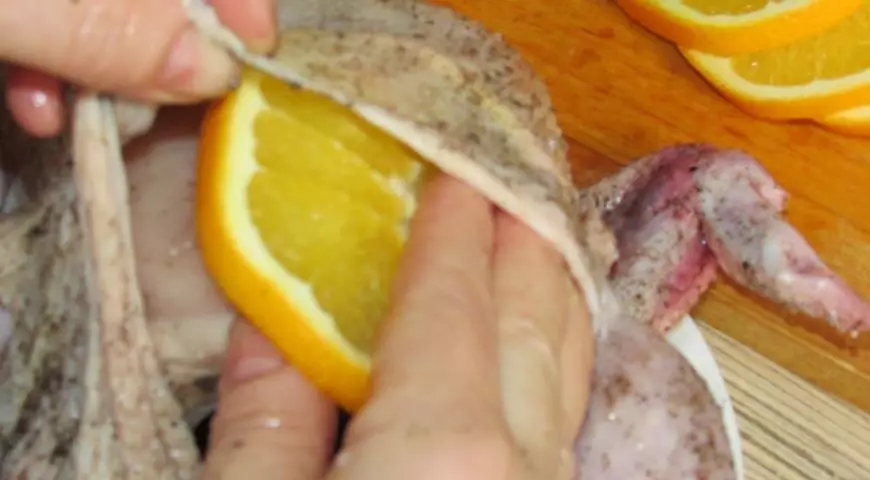 在皮肤鸡肉橙片下面，把大蒜放在尸体里面