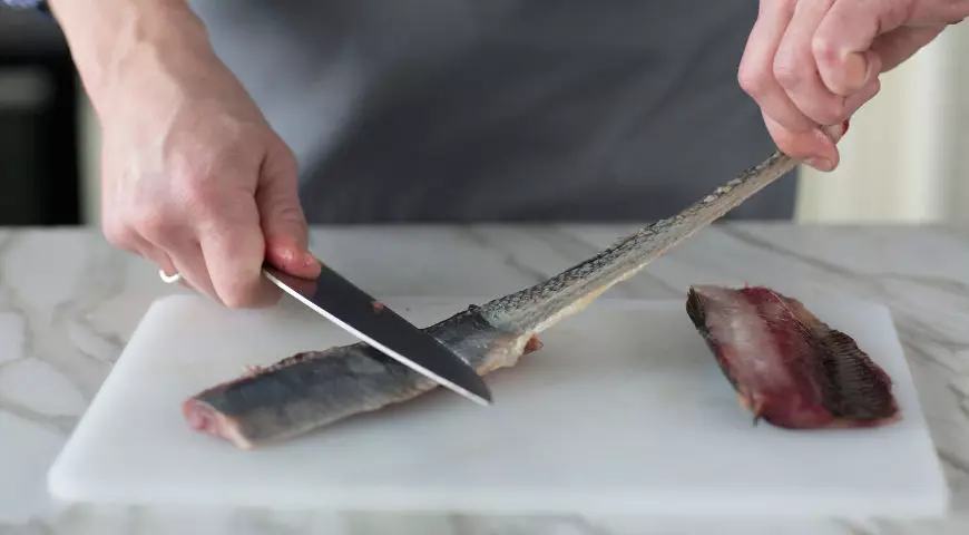 Memotong herring yang berkepala rendah di fillet