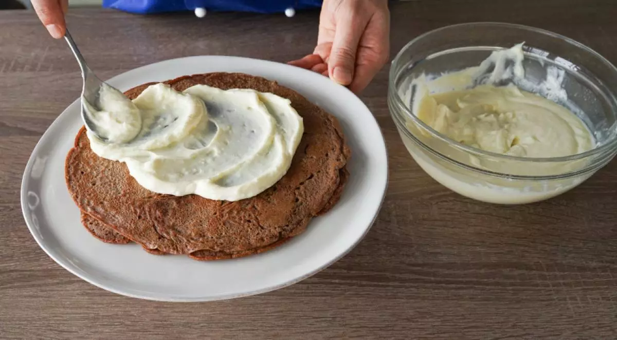 Een pannenkoekencake met cottage kaascrème, smeer de eerste root van gecondenseerde melk
