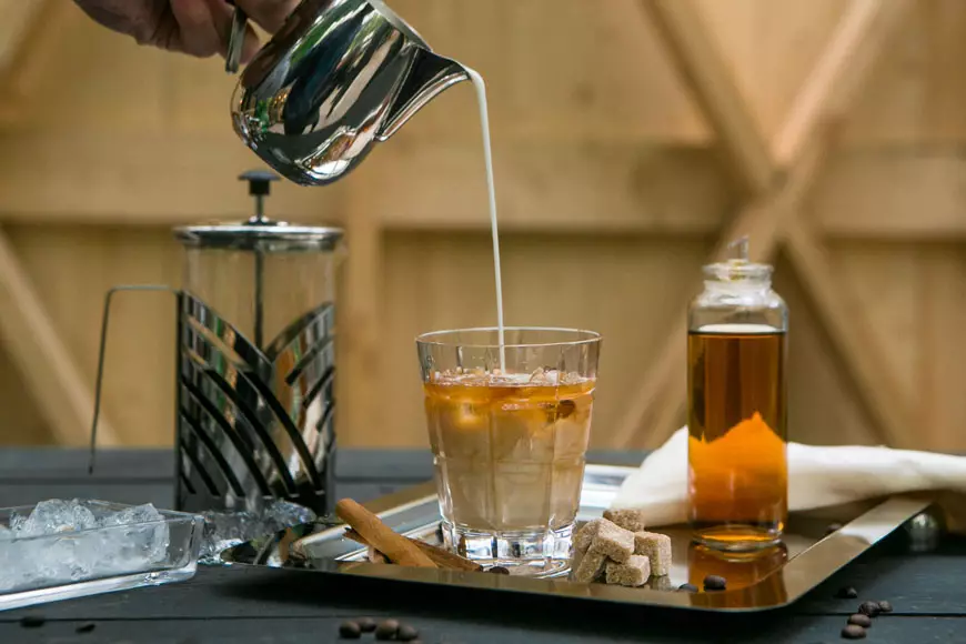 Despeje o café Amaretto em vidros com cubos de gelo