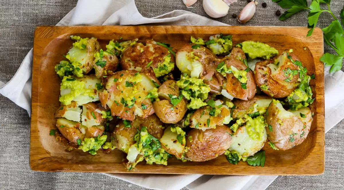 Nuimkite bulves nuo orkaitės ir pabarstykite smulkiai pjaustytų petražolių ir šviežių pipirų. Supilkite padažą iš avokado ir nedelsiant tarnauti prie stalo.