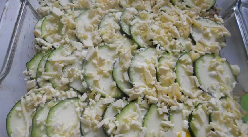 Ar an mionfheoil ag líonadh an zucchini atá fágtha, táimid ag uisce an líonadh, an cáis sprinkle