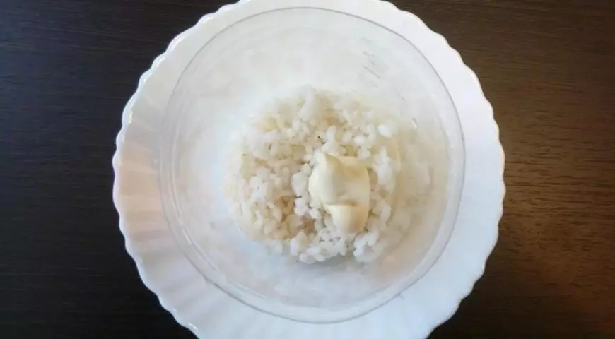 Připravte složky, první vrstva položila vařenou rýži, namažte ji s majonézou