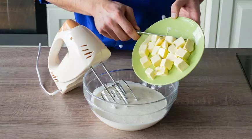 Behuizing, eieren dragen een mixer met suiker om een ​​weelderige massa homogene consistentie te krijgen, voeg zachte boter toe