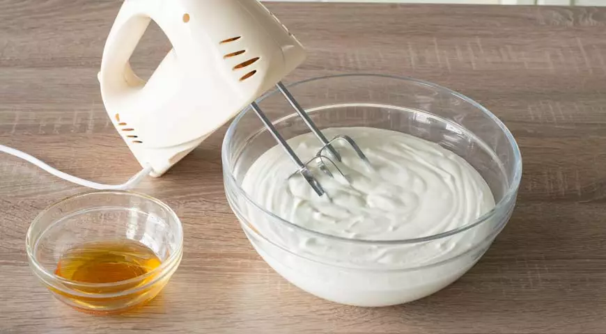 住房，准备奶油：良好的酸性奶油。击败郁郁葱葱的质量，逐渐添加糖和蜂蜜