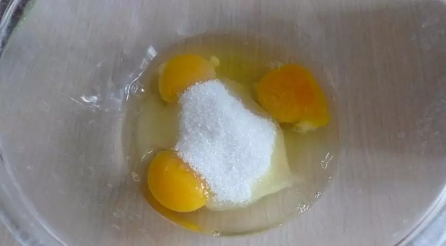 Azotar huevos con azúcar para cocinar pastel de cerezo