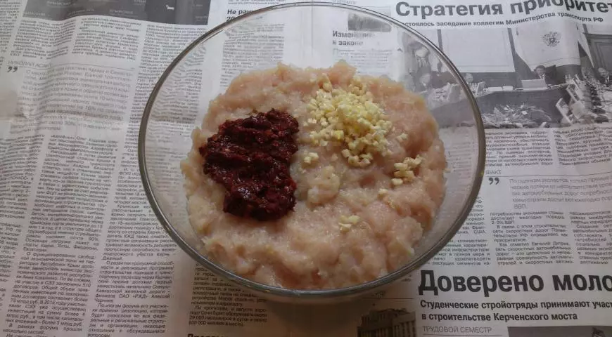 Idagdag sa chicken minced adzhika, bawang at asin, ihalo nang lubusan