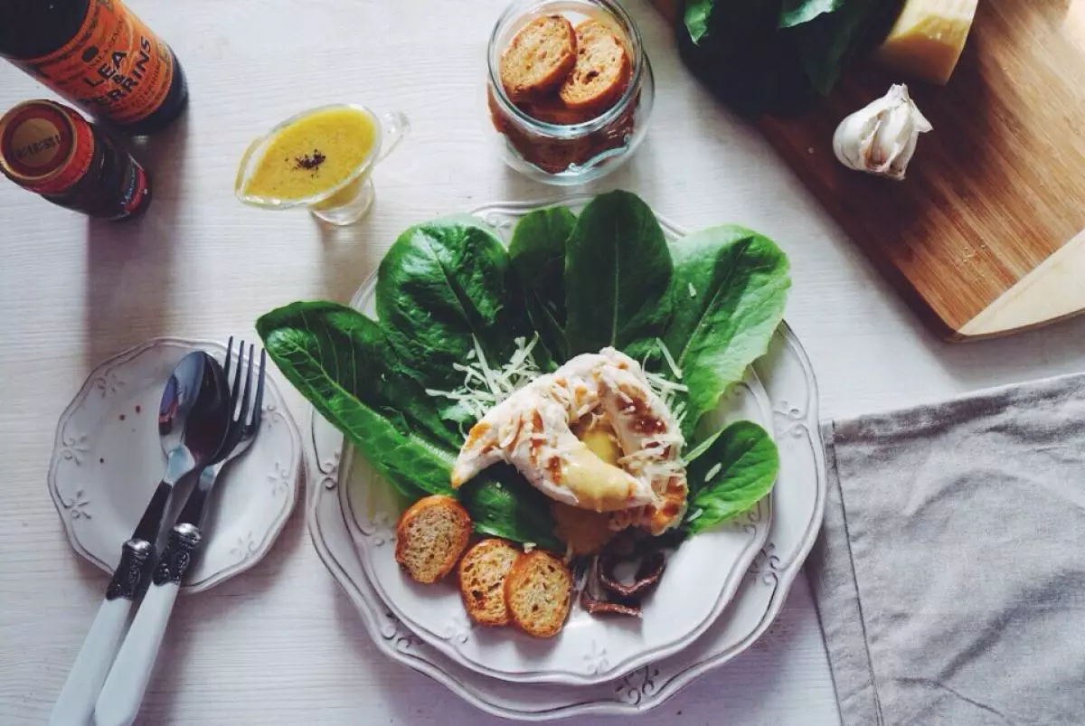 Undirbúningur keisarasalat með hvítlauks croutons og salat Romain