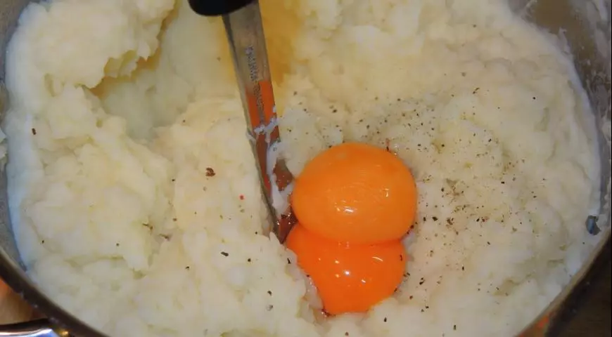 Dodajte žumanjke i vrhnje u pire krompir, mix