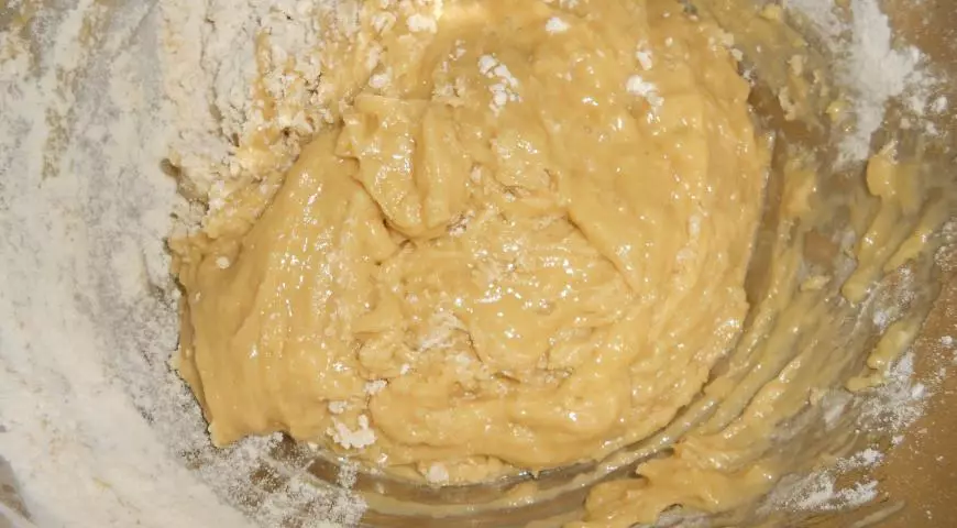 Ajoutez de la farine à une masse d'huile de miel pour la cuisson de la pâte