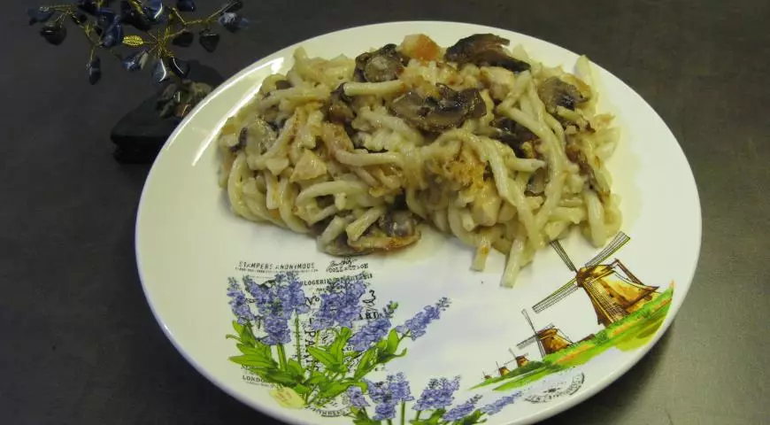 Spageti i butë me pulë dhe kërpudha vënë në sobë dhe kuzhinier në trashje