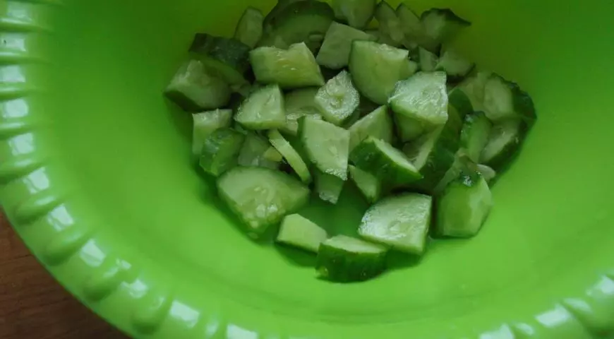 Potong mentimun untuk salad dengan kerang