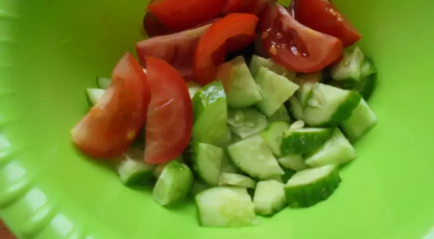 Potong tomat untuk salad dengan sayuran