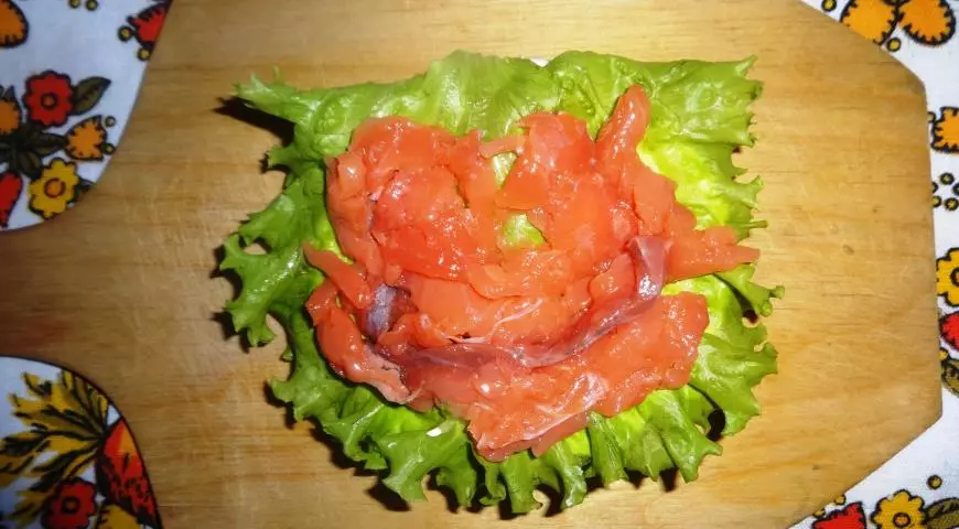 Cobrir um pão com uma folha de salada e colocar uma truta nele