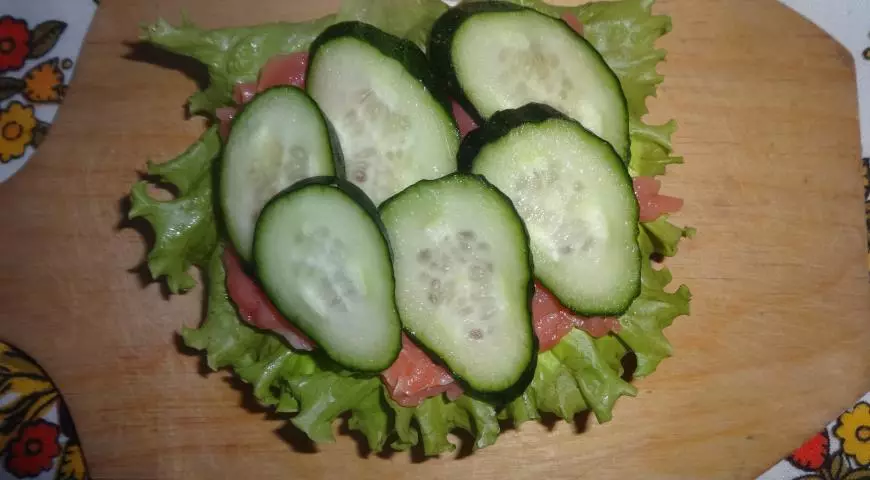 Ponga las rebanadas de pepino en el pescado.