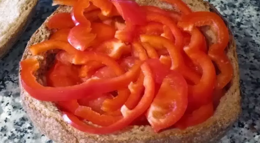 Setzen Sie Tomaten und Paprika auf das Brötchen