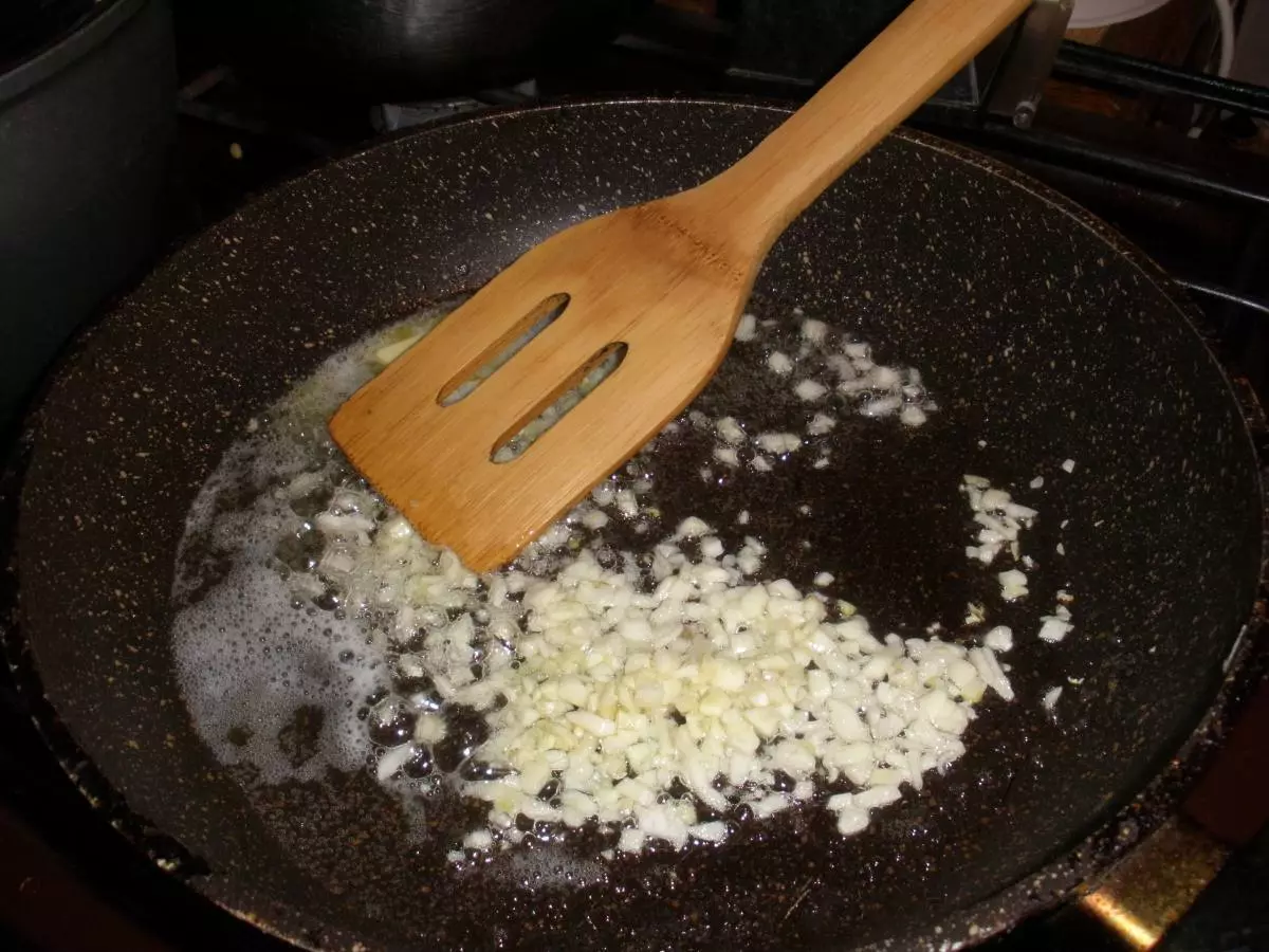 8 Calore metà dell'olio d'oliva in una padella, mettere l'aglio e riscaldare 30 secondi, aggiungere cipolle e friggere fino al morbido.