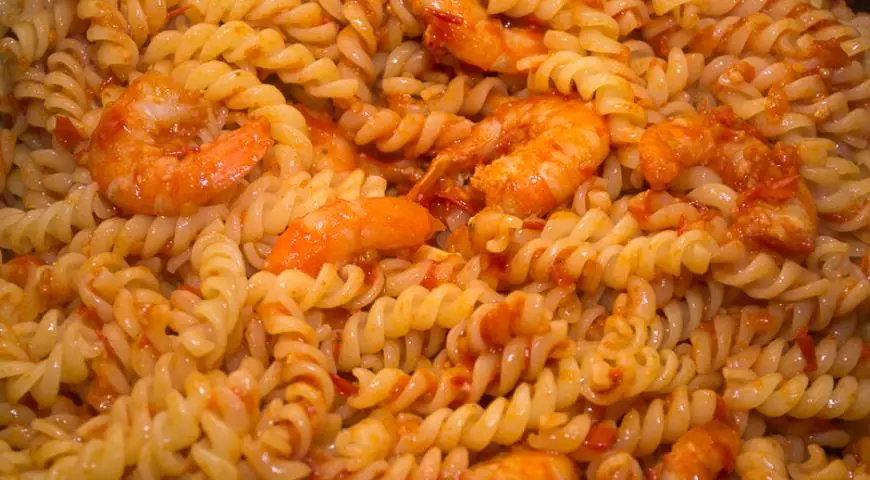 Barrejar la pasta amb gambes i salsa de tomàquet sec