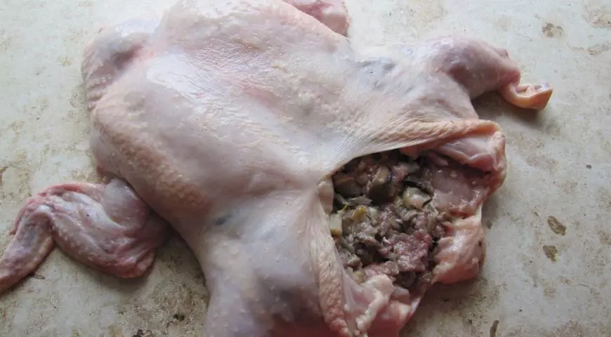 Ompliu el farciment de la carcassa de pollastre, cosir tallat, sal i pebre