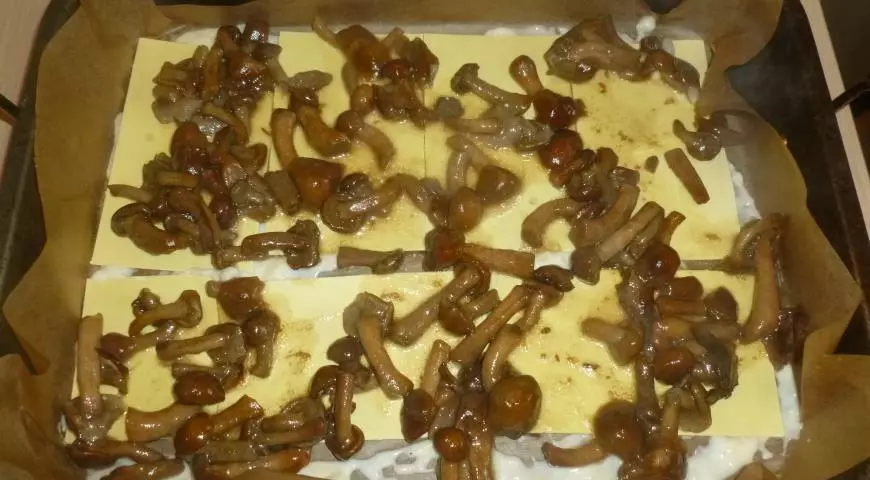 Sa ilalim ng form ay naglalagay ng sarsa, bahagi ng mga sheet para sa lasagna at inihaw na mushroom