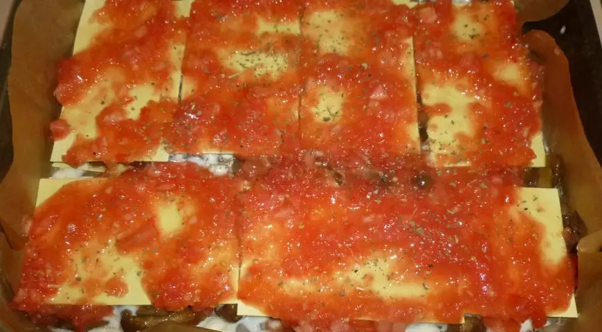 Cubrir os cogomelos para Lazagany, establecer salsa de tomate e albahaca, repetir capas e poñer no forno