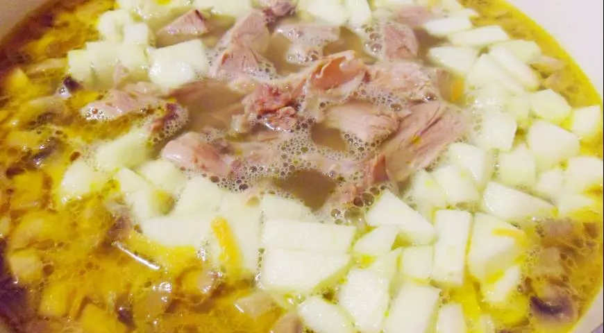 Filet d'ànec per tallar sopa, juntament amb les pomes posades en una cassola