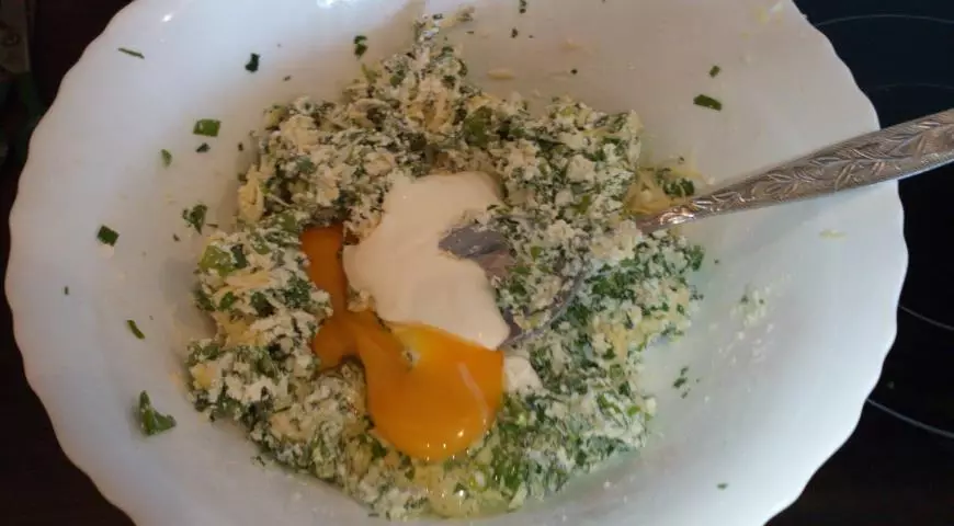 Zmiešajte chatový syr, zelené, vajcia a kyslá smotana, pridať korenie