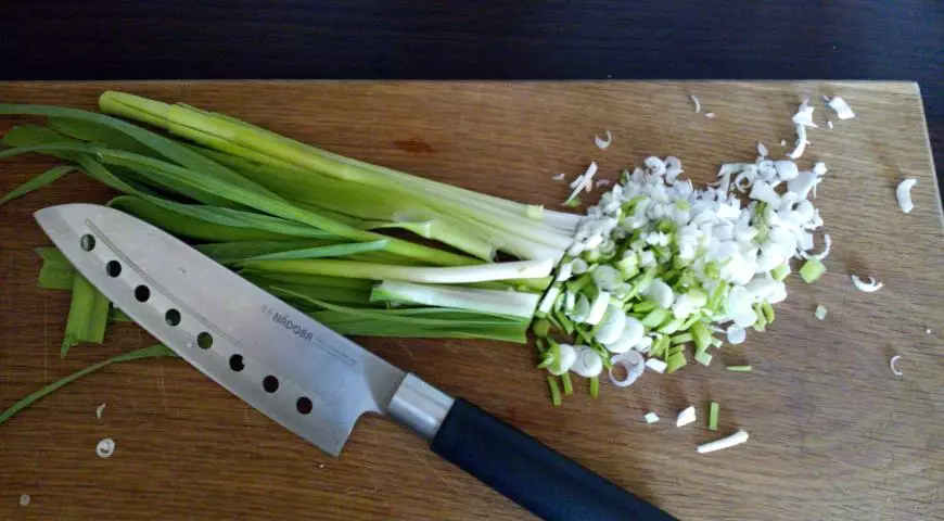 Schneiden Sie einen jungen Knoblauch mit Stielen