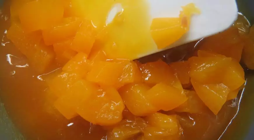 Magdagdag ng mga cube ng peach sa pinainit mago puree para sa compote Mango Peach