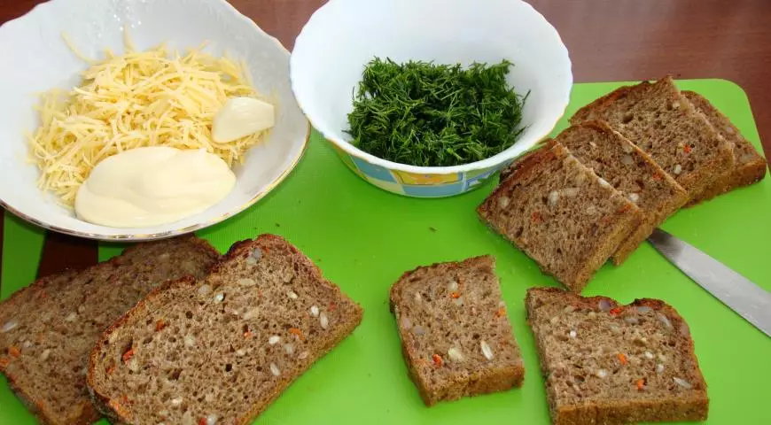 Nós fazemos a base da clareira para leitões de fatias de pão, queijo, alho, vegetação e maionese