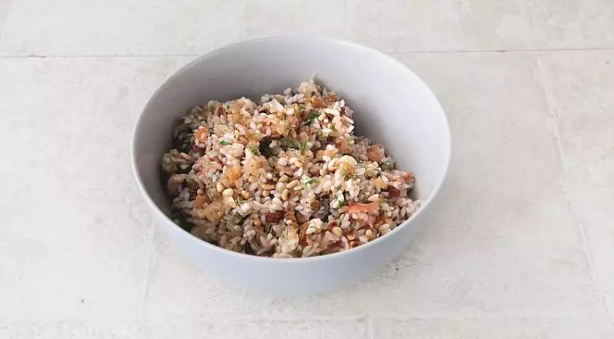 Для долми з рисом і родзинками змішайте промитий рис, цибулю з родзинками, кедрові горіхи, терті помідори і петрушку