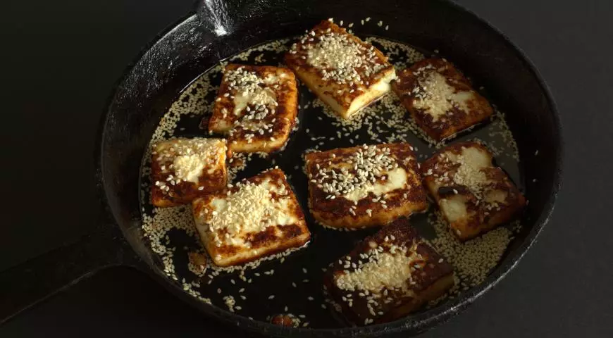 Fry queijo no óleo vegetal, polvilhando-o em sésamo