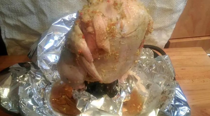 Accrocher la carcasse de poulet sur une bouteille et cuire à une croûte d'or