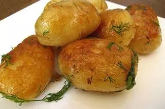 Patatas na inihaw sa isang kasirola na may bawang at dill.