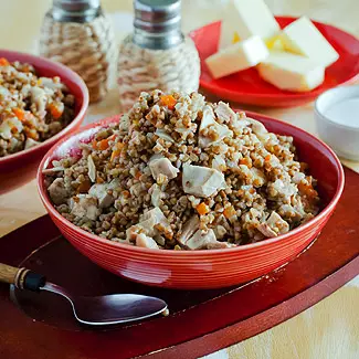 Bubur gandum pada kaldu ayam dalam kompor lambat