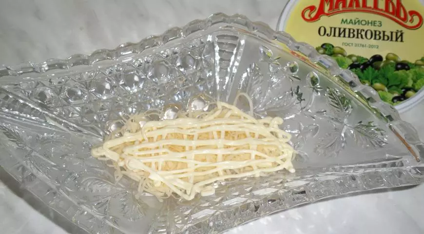 I salatdrakten legger vi en del av revet ost, vanning majones