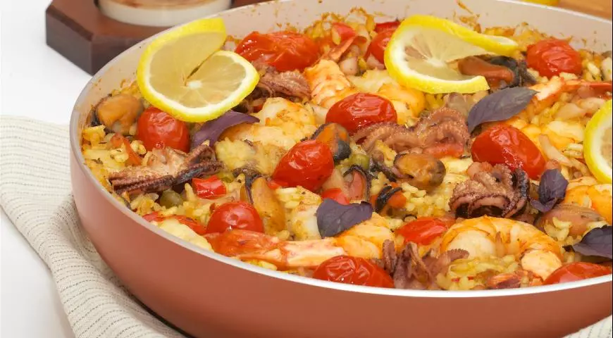 Paella con frutti di mare Decora il limone e i verdi