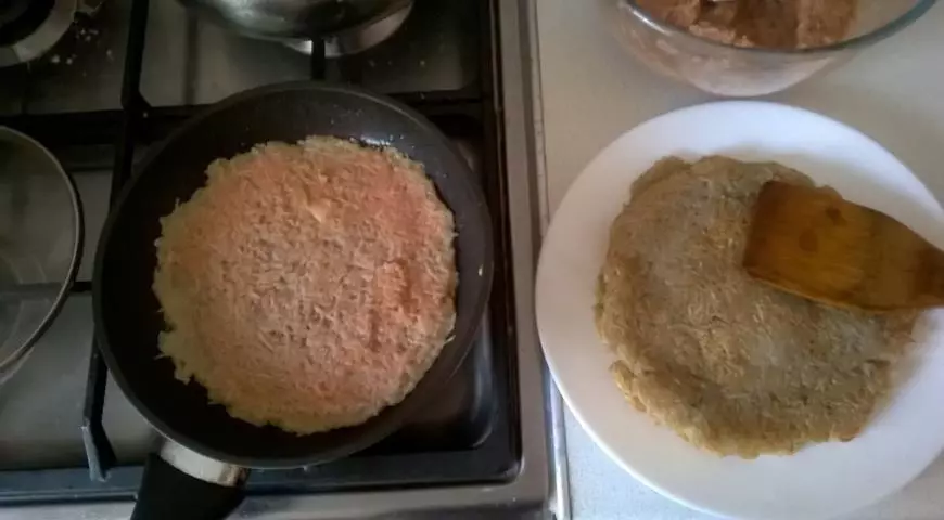 Fry-aardappelpannenkoeken voor cake met ui en wortelen