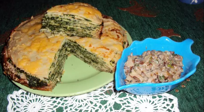 Un pastel de panqueques con espinacas y salsa de setas.