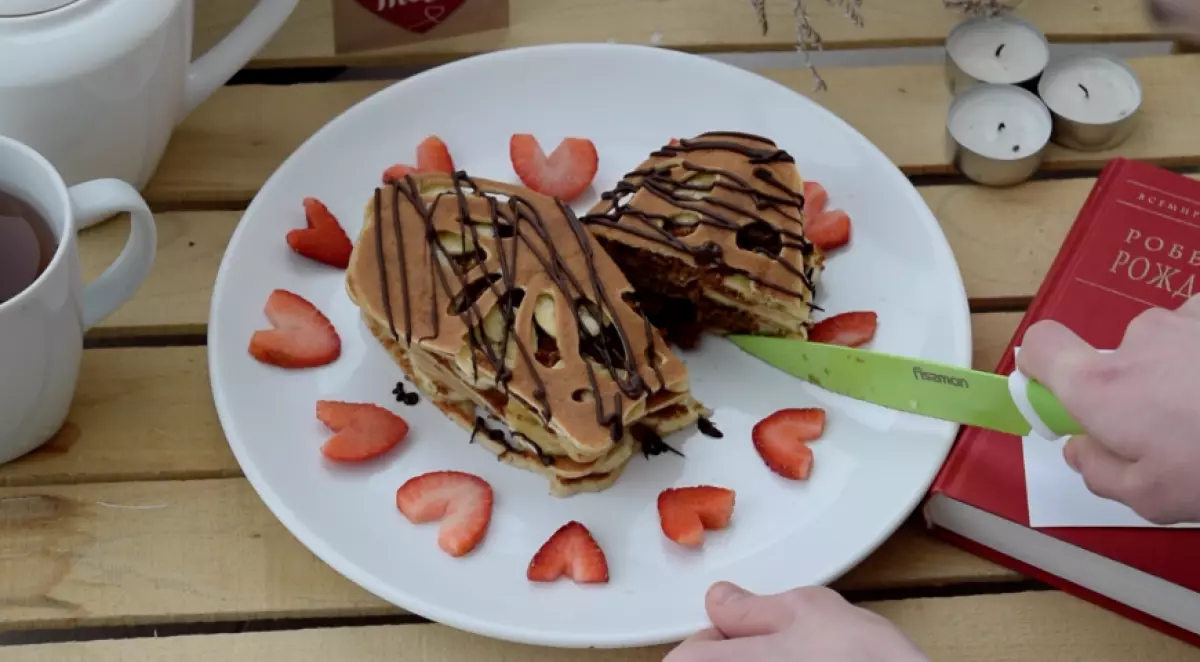 Dekorera jordgubbe en pannkaka tårta med jordnötter och banan för Alla hjärtans dag