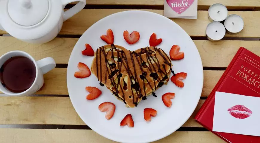 Förbereder en pannkaka tårta med jordnötter och banan för Alla hjärtans dag