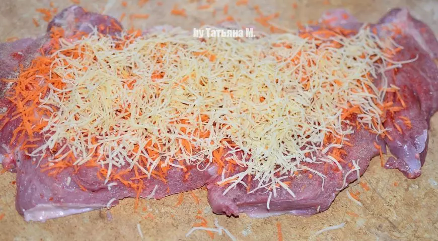 Посипаємо м'ясо для рулету тертими морквою і сиром