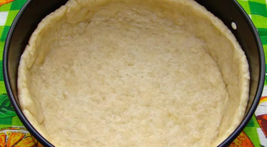 Розкачати охолоджене тісто і викласти у форму для випікання