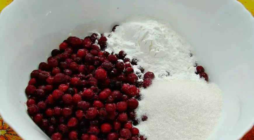 Ανακατέψτε τα συστατικά για την προετοιμασία μιας πλήρωσης lingonberry, το διανέμει με δοκιμή
