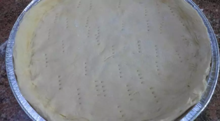 Onion pie with young potatoes, lay out the dough into the shape, pokulk forks
